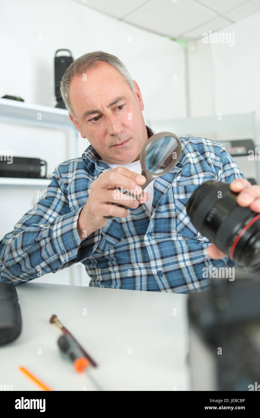 male repairing an camera at his workplace on white background Stock ...