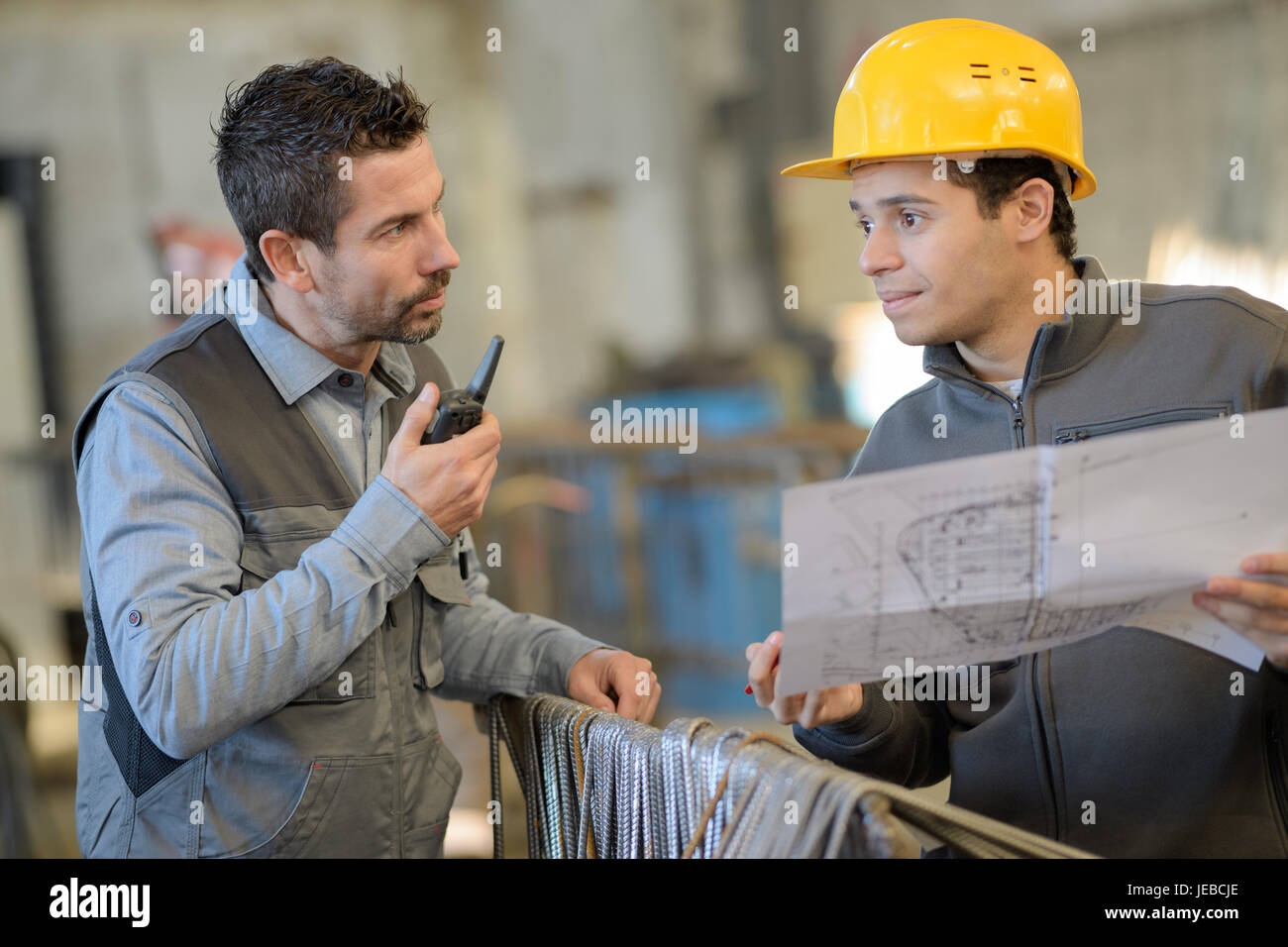 engineer and worker checking plan on construction site Stock Photo - Alamy