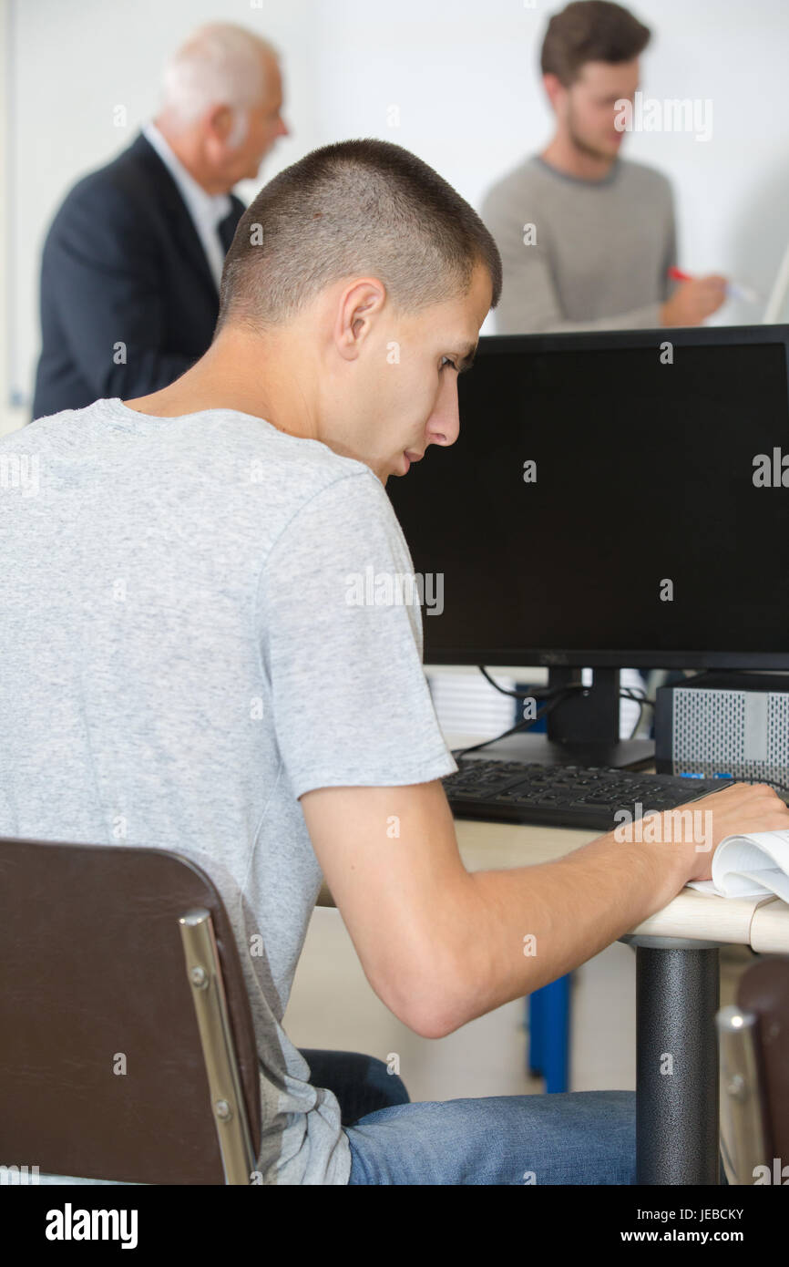 computer teacher assisting a student in classroom Stock Photo - Alamy