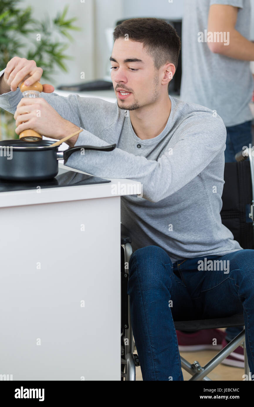 disabled young man in wheelchair is cooking Stock Photo - Alamy