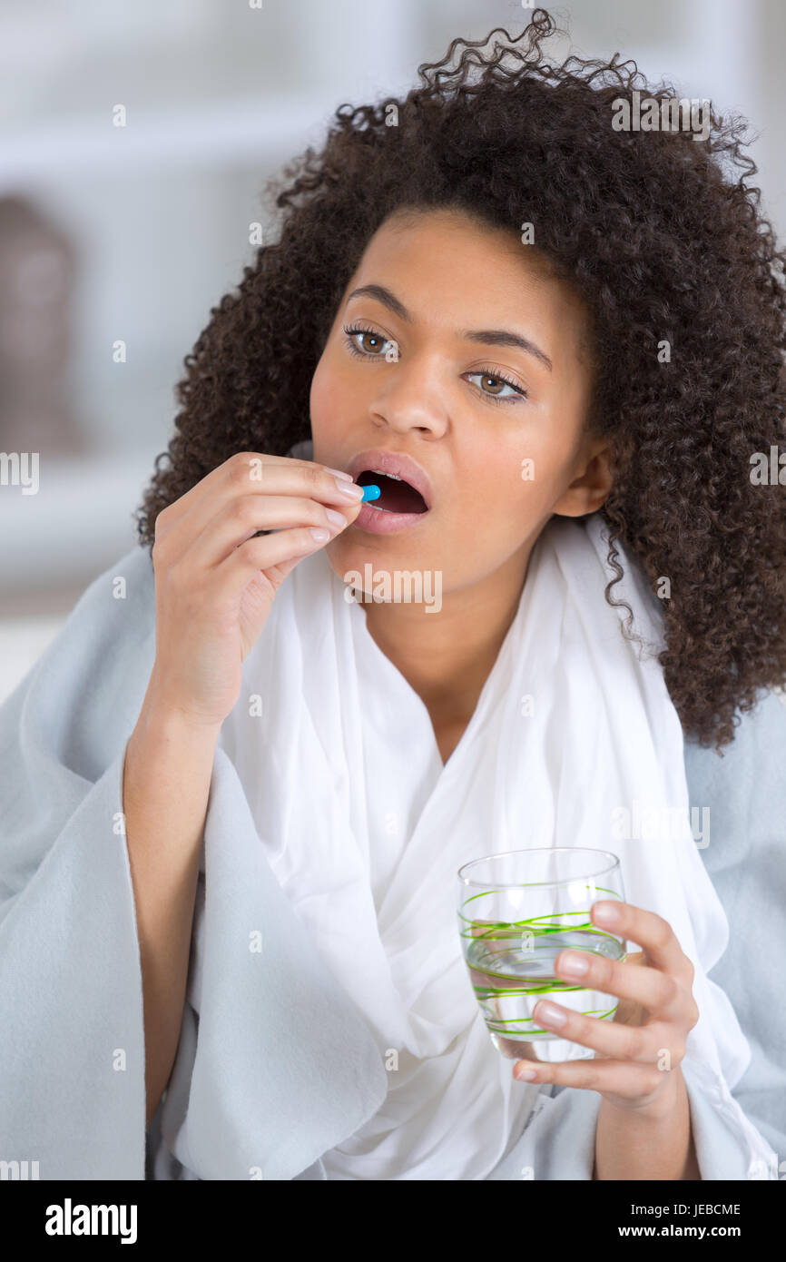young woman taking pill Stock Photo - Alamy