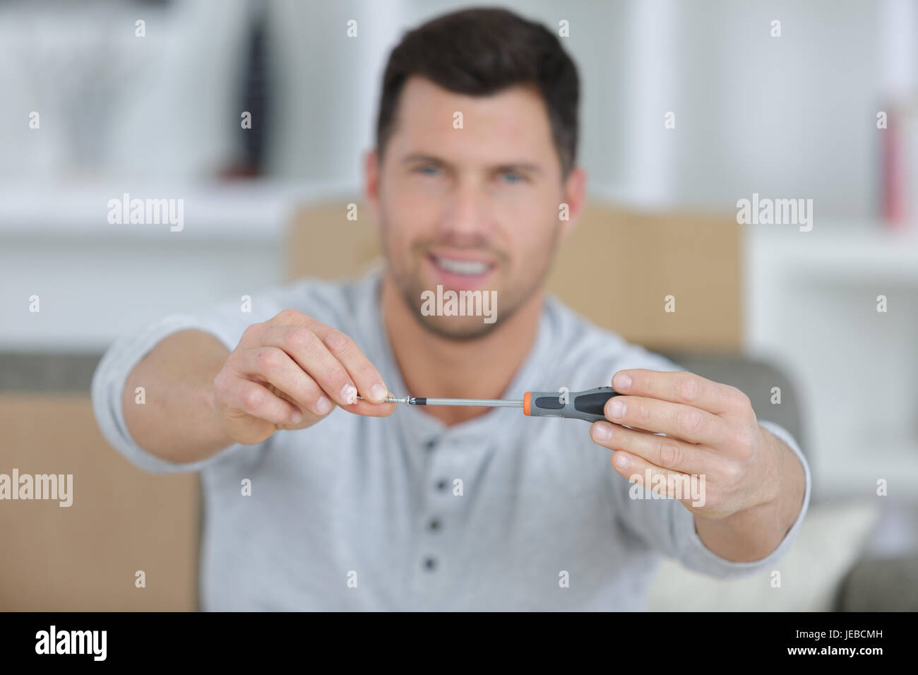 positive man showing a screwdriver Stock Photo - Alamy
