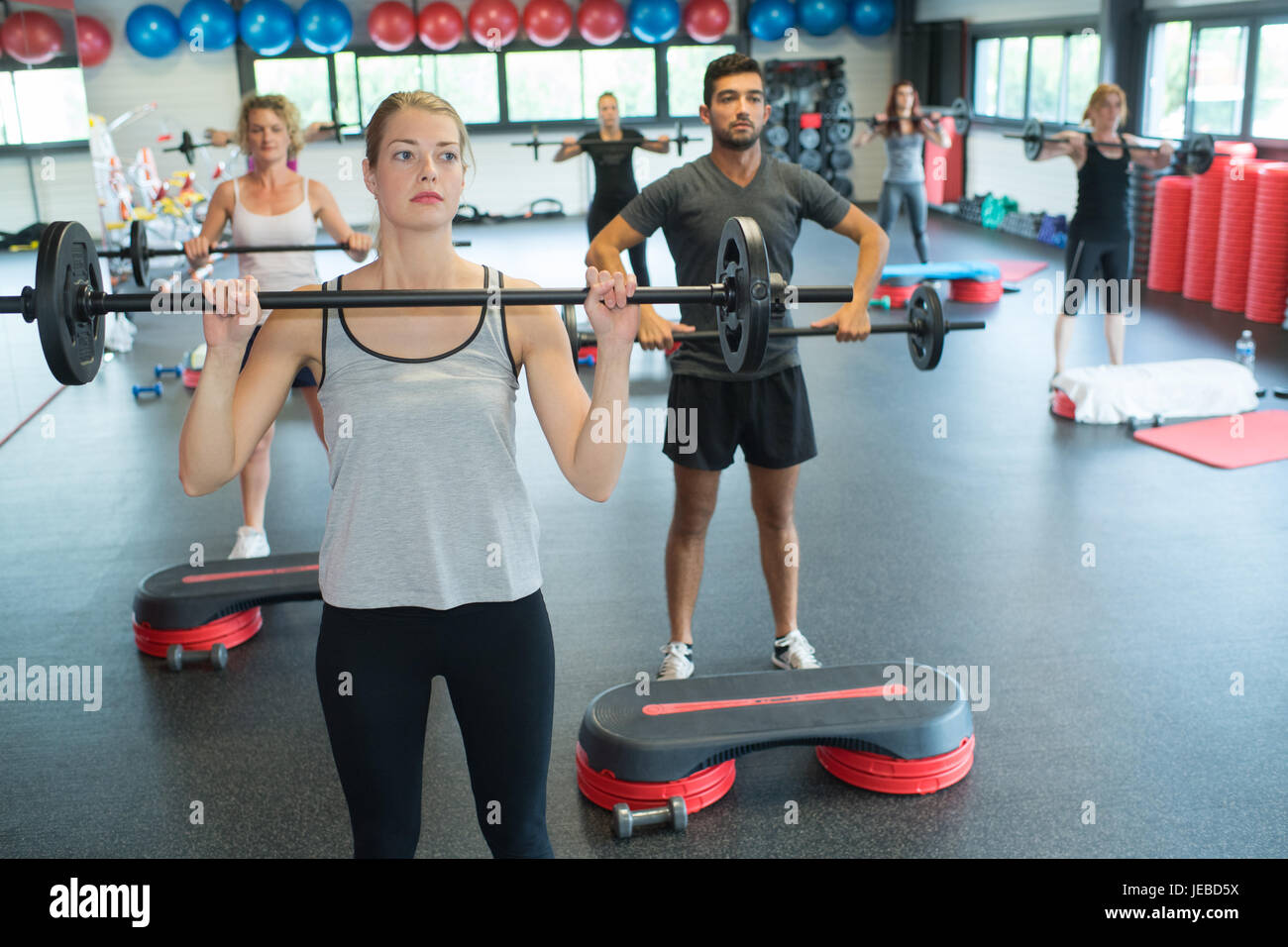 group of people exercising with bars in gym Stock Photo - Alamy