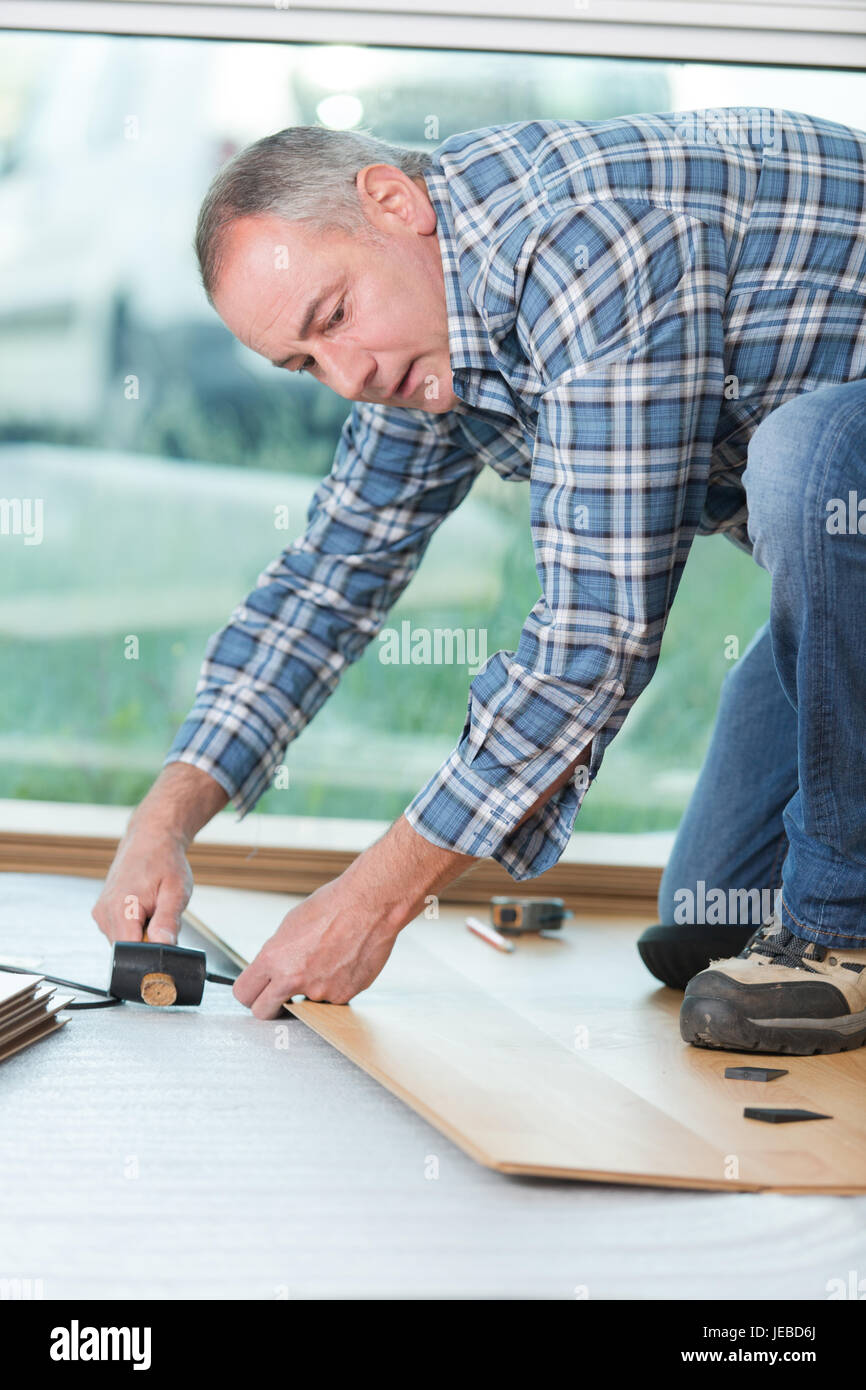 carpenter lining parquet boards to each other fitting a plank Stock ...