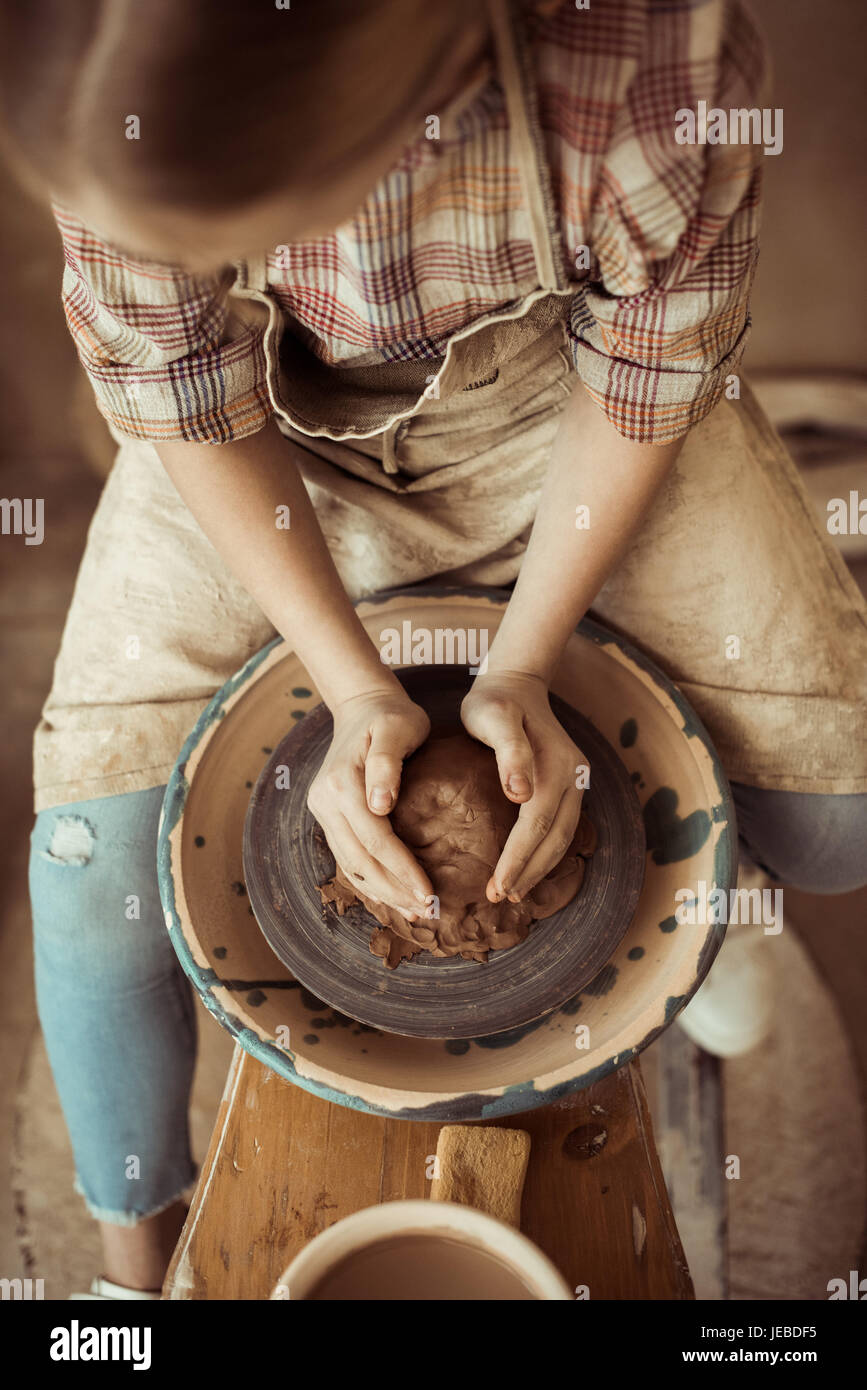 Overhead view of little girl making pottery on wheel at workshop Stock ...