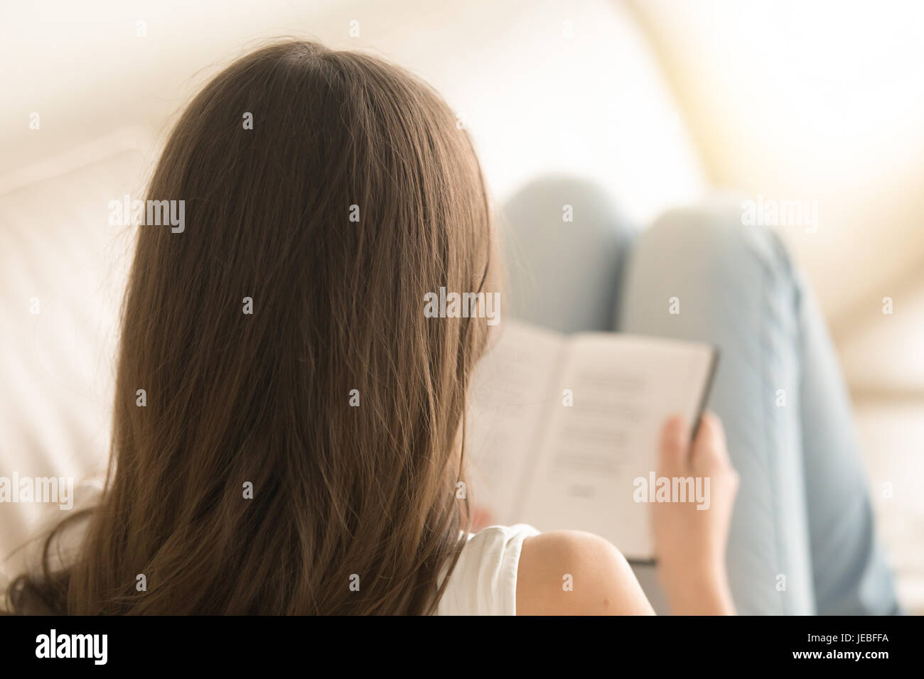 Woman reading interesting book on sofa at home Stock Photo - Alamy