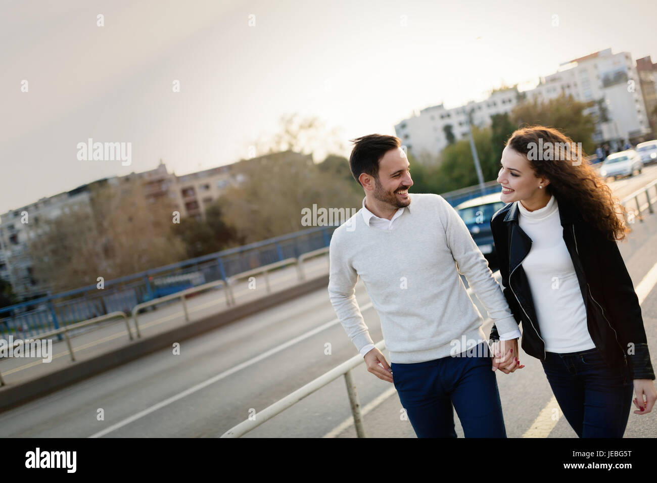 Happy young couple walking hand in hand Stock Photo - Alamy