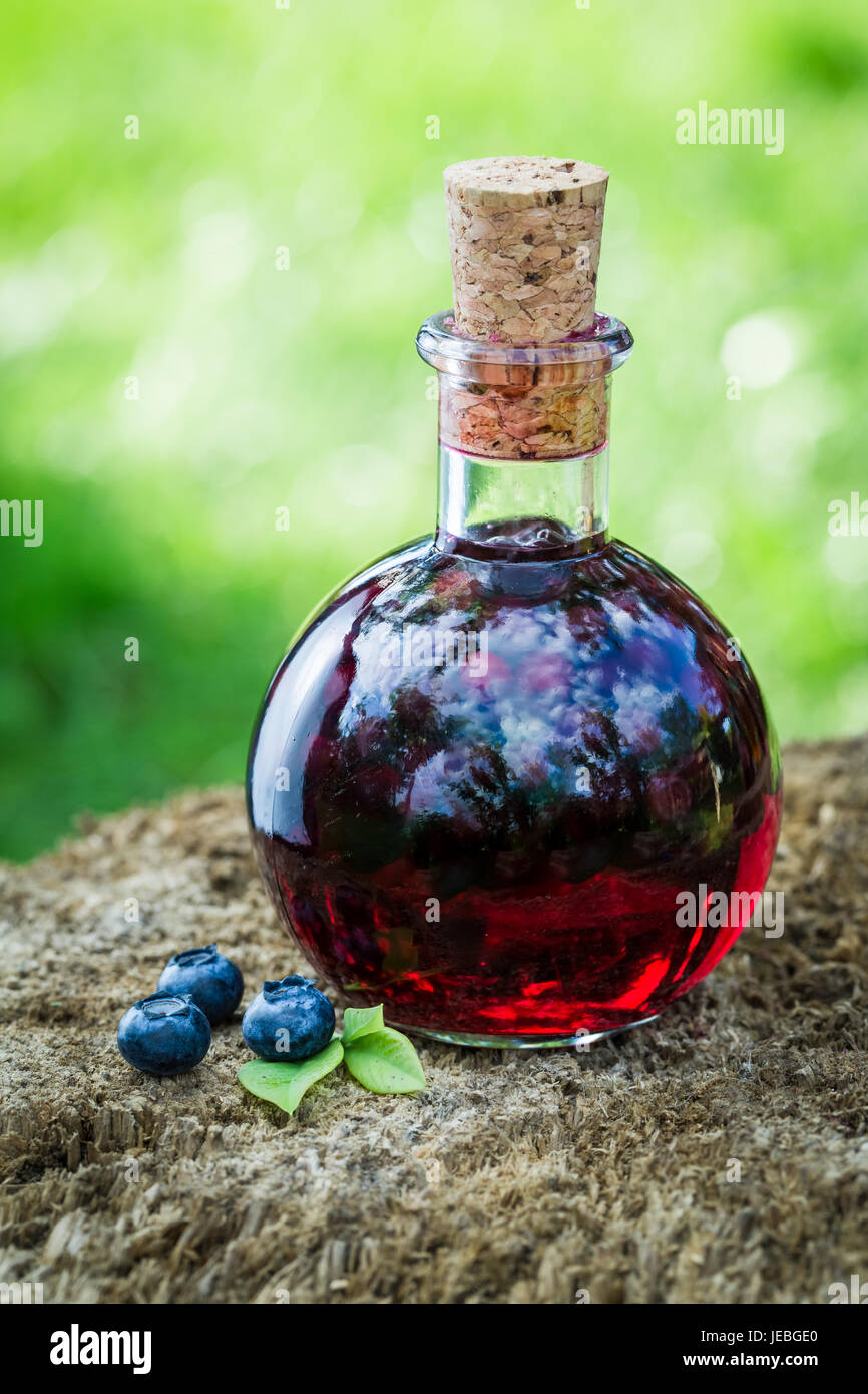 Sweet liqueur in a bottle with blueberries in summer Stock Photo - Alamy