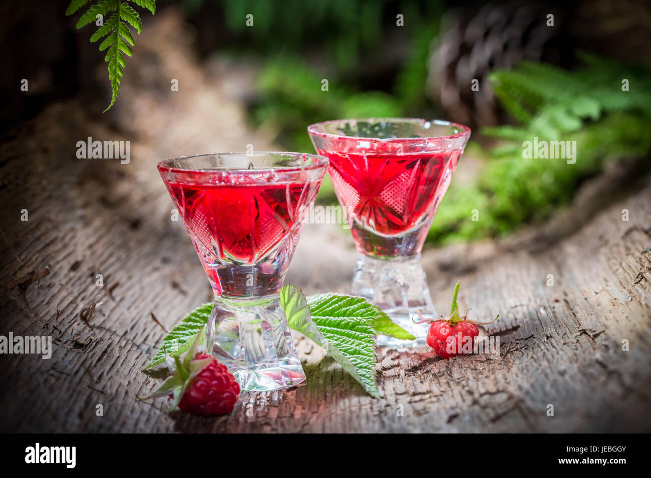 Sweet raspberries liqueur made of alcohol and fruits in forest Stock ...