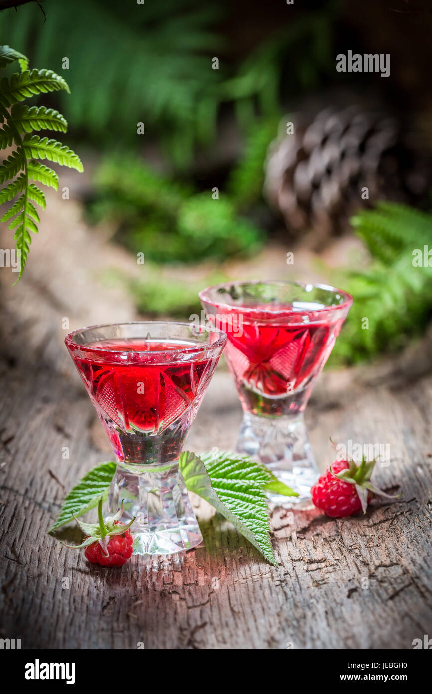 Tasty raspberries liqueur made of fruits and alcohol in forest Stock ...