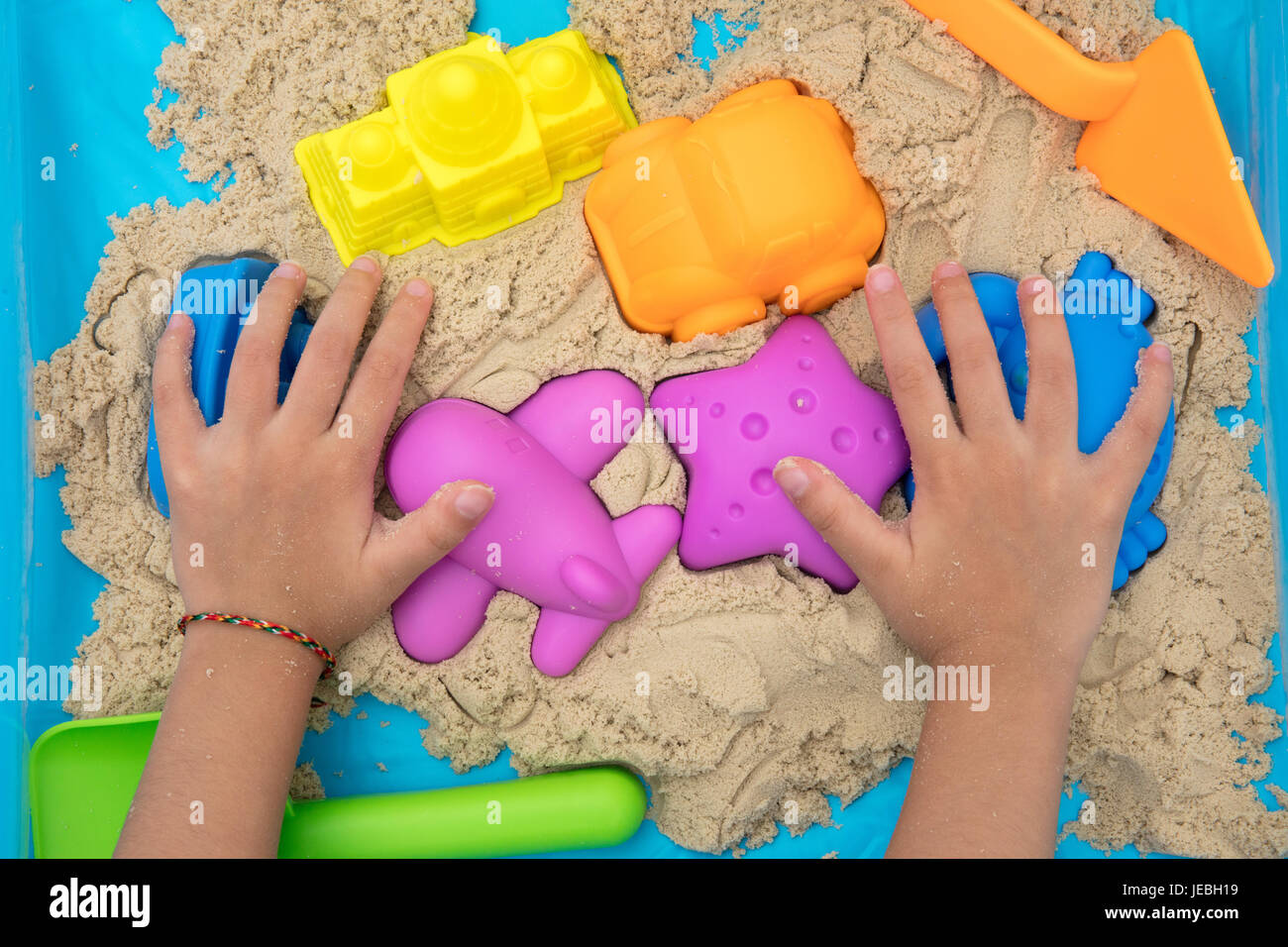 Child's hand close up playing sand at home indoors Stock Photo - Alamy