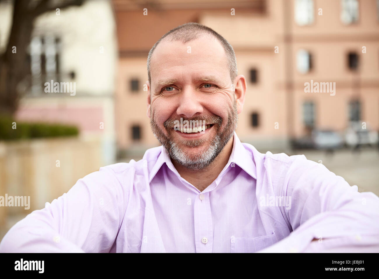 Portrait of happy casual man in urban space Stock Photo - Alamy