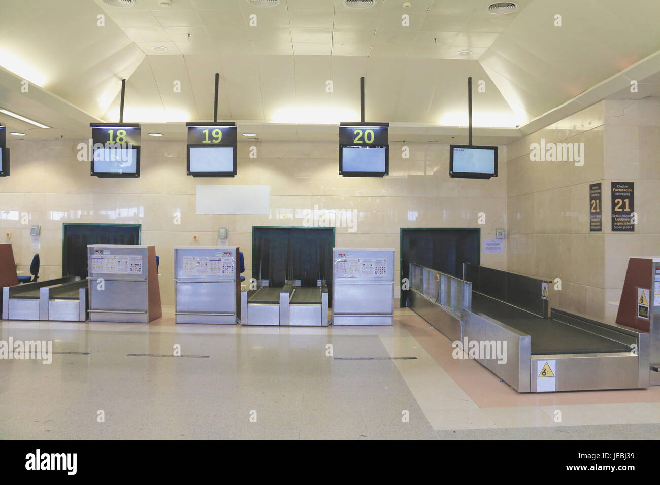 Luggage check-in counters at an airport Stock Photo - Alamy