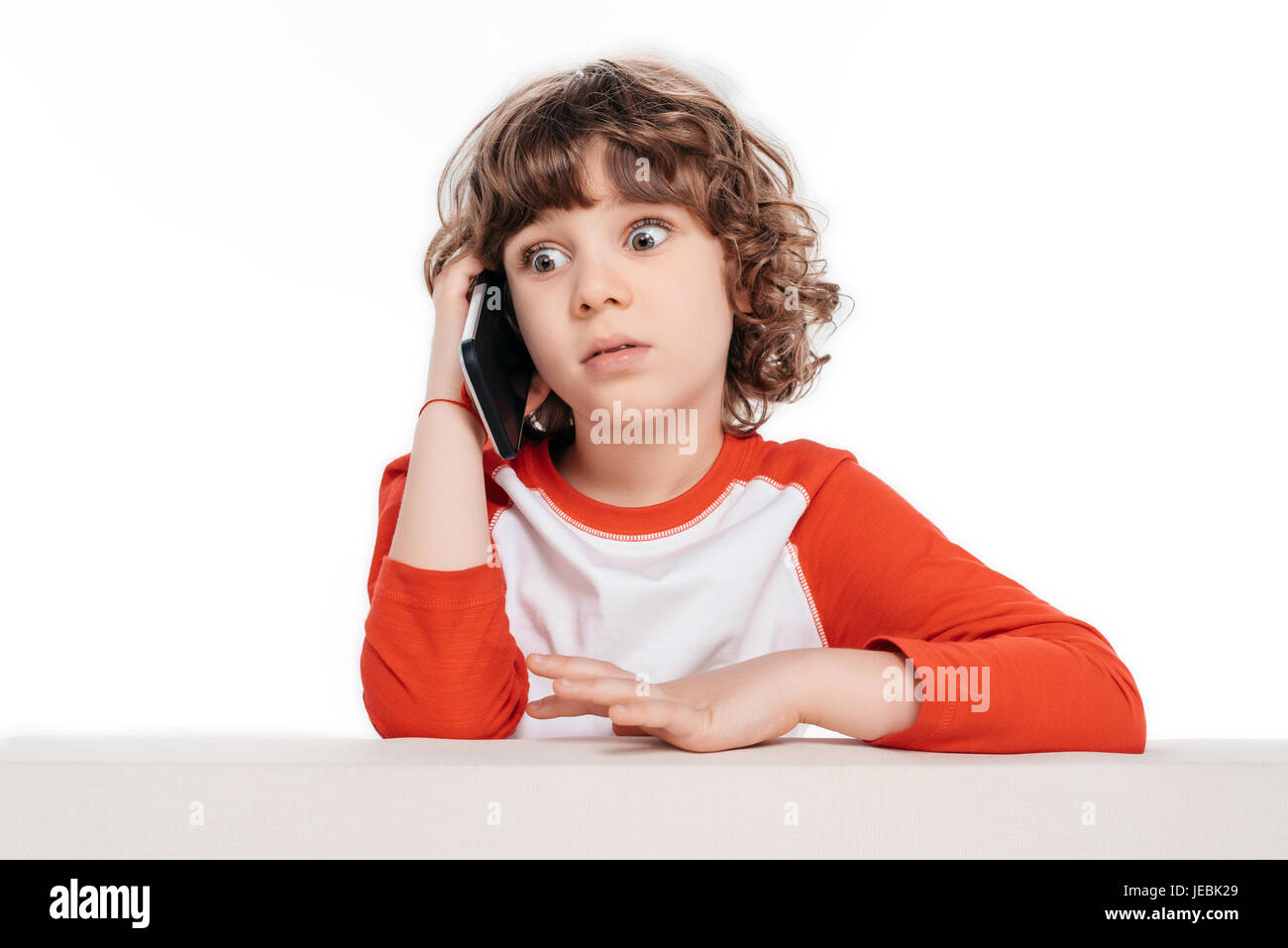 Cute little boy talking by smartphone with shocked expression Stock ...