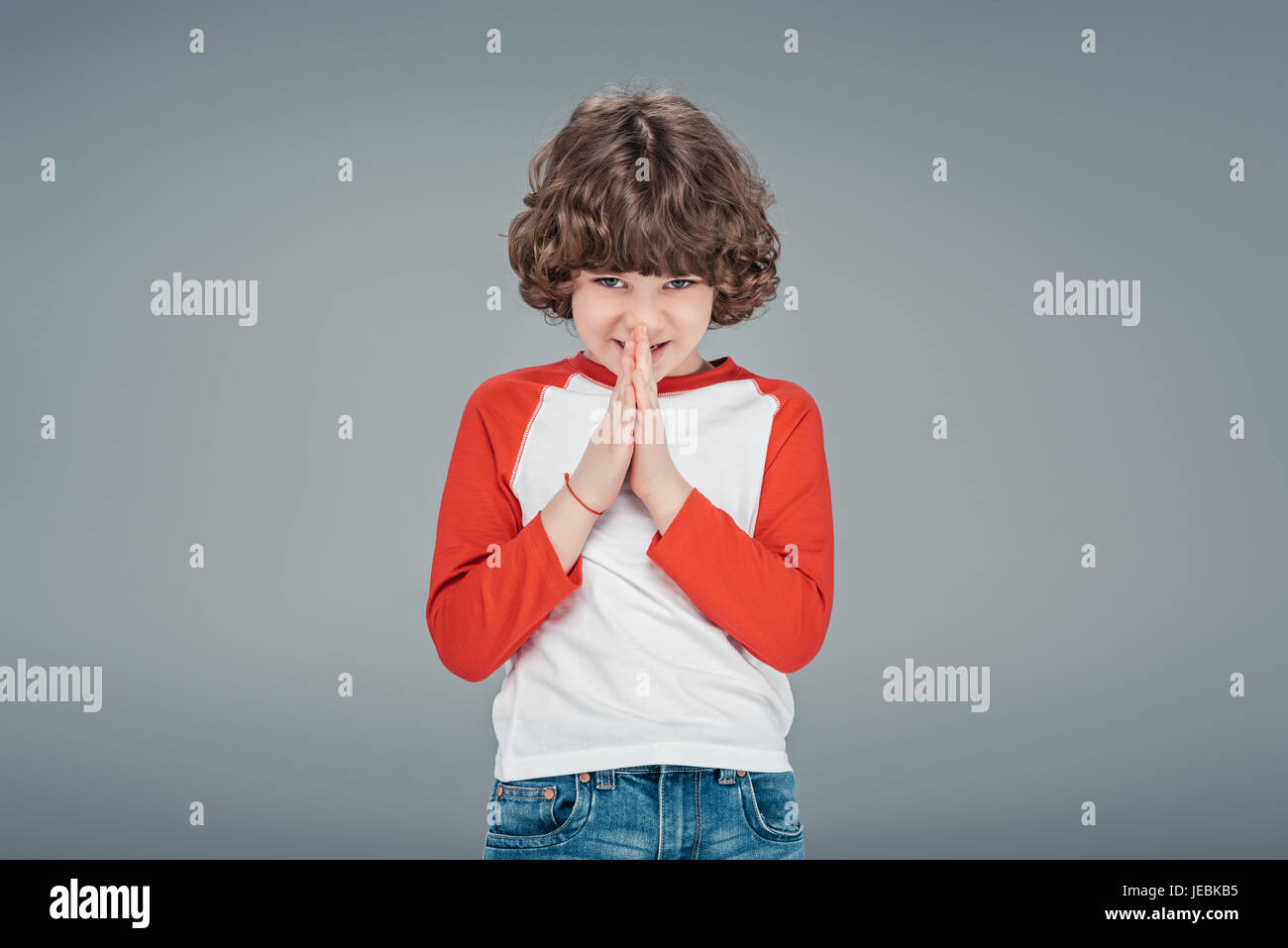 Little boy standing and looking at camera isolated on gray Stock Photo ...