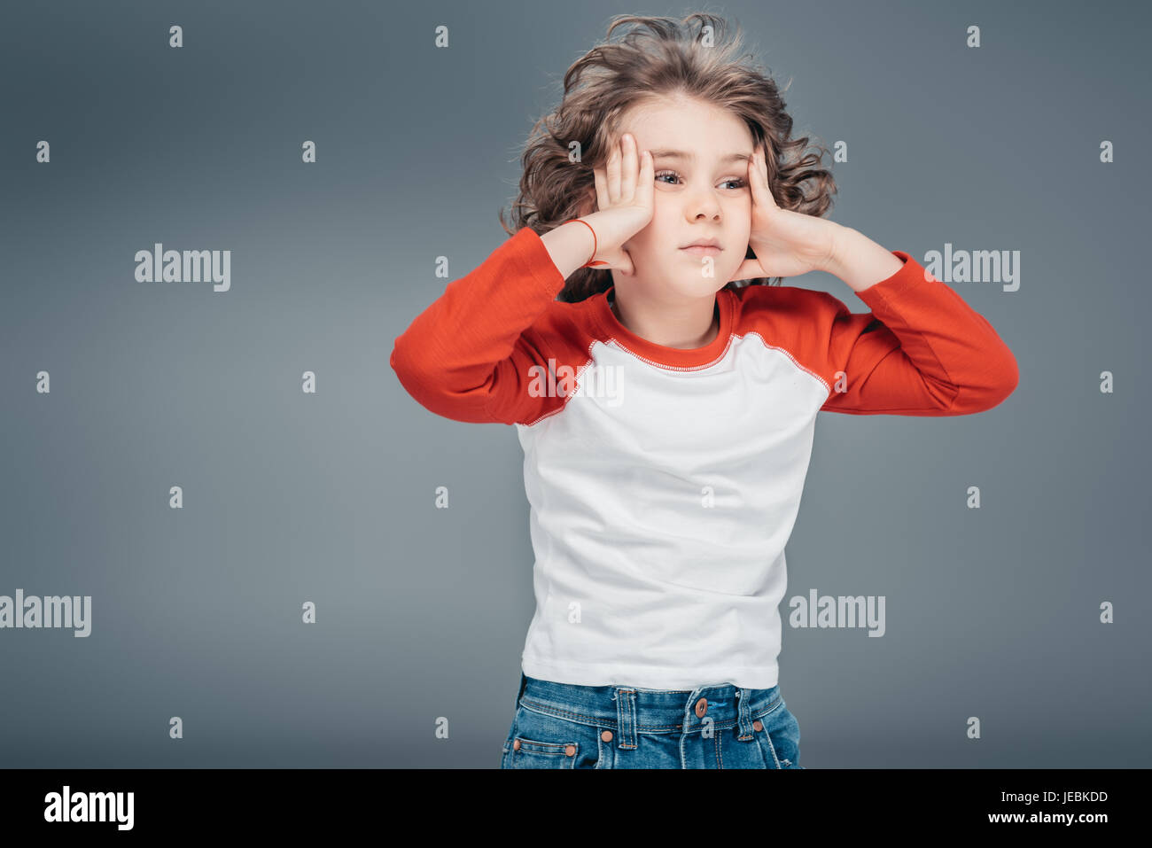 Cute boy touching face by hands isolated on gray background Stock Photo ...