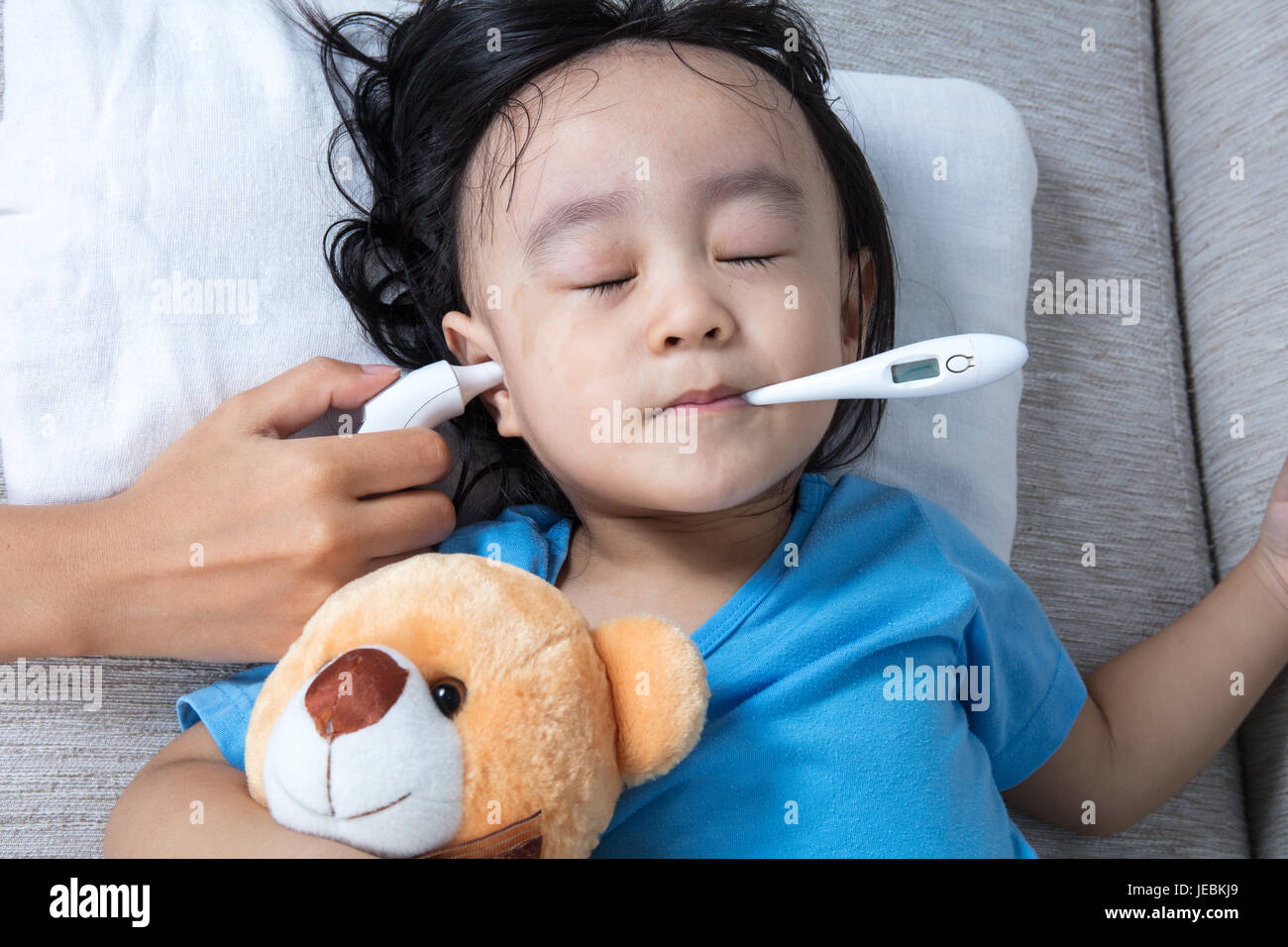 Asian Chinese little girl getting ear measurement for fever temperature ...