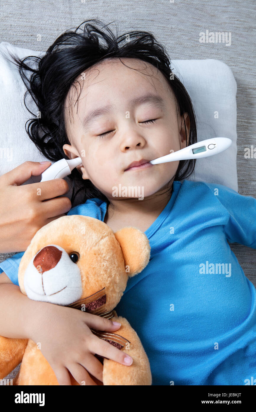 Asian Chinese little girl getting ear measurement for fever temperature ...