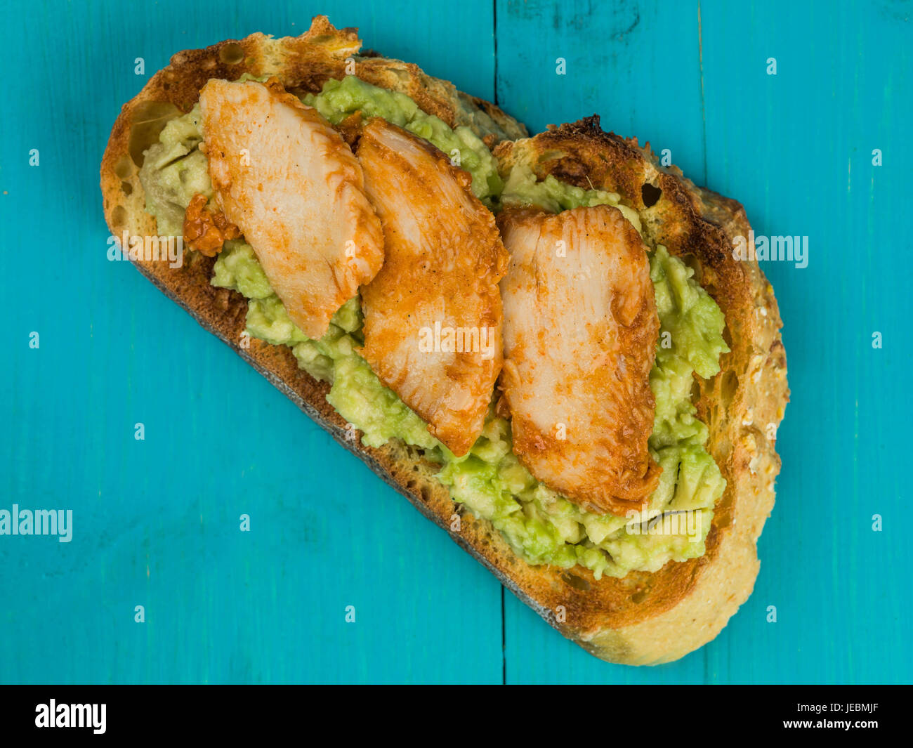 Sliced Chicken and Avocado on Toasted Corn Bread Against a Blue ...