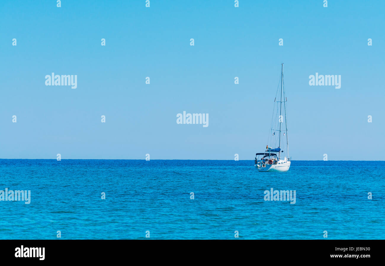 Boat alone in the blue sea Stock Photo - Alamy
