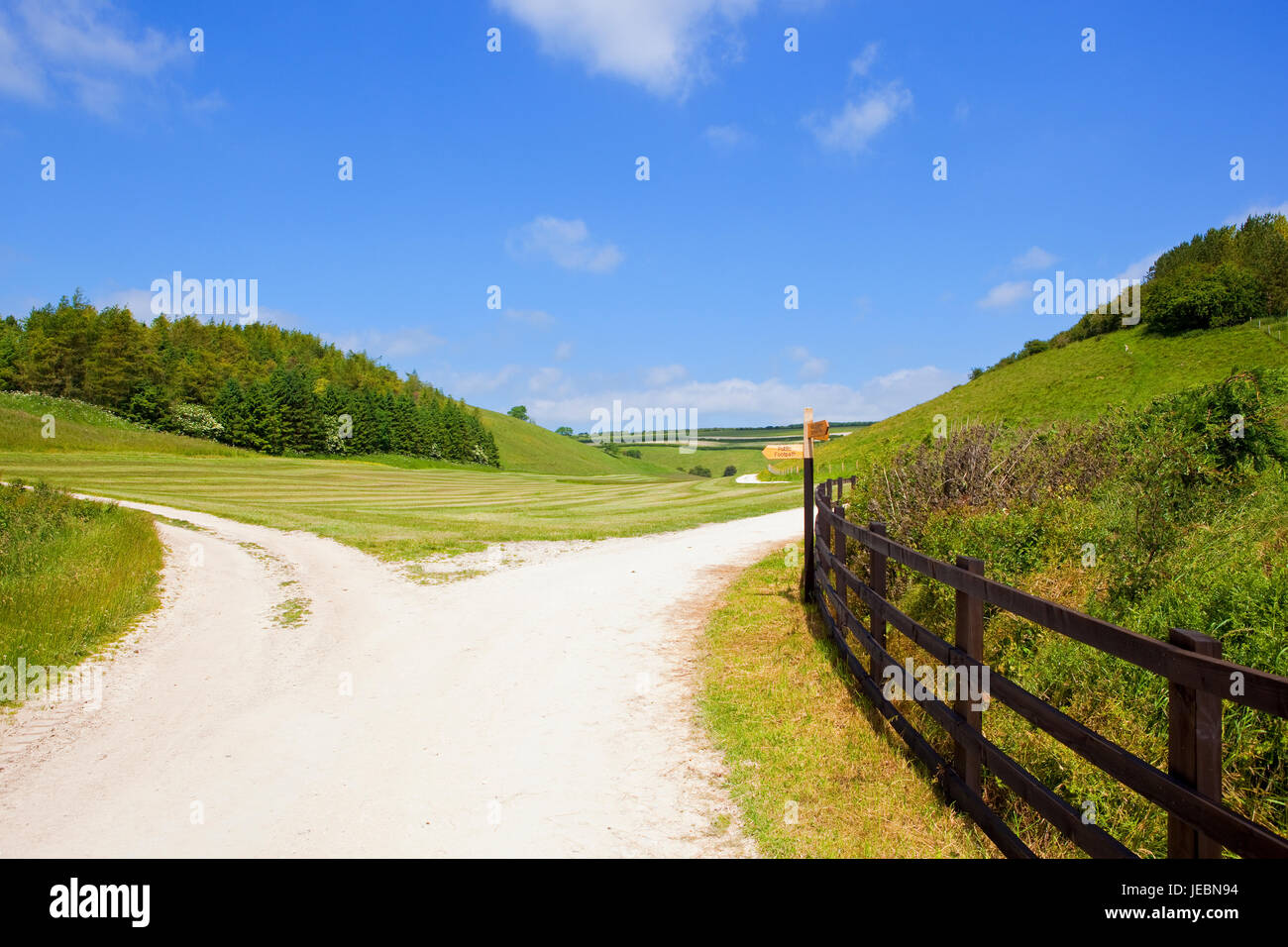 a white limestone country bridleway and footpath with wooden sign in ...