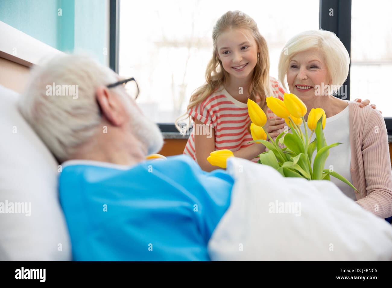 grandmother and granddaughter with tulip flowers visiting patient in ...