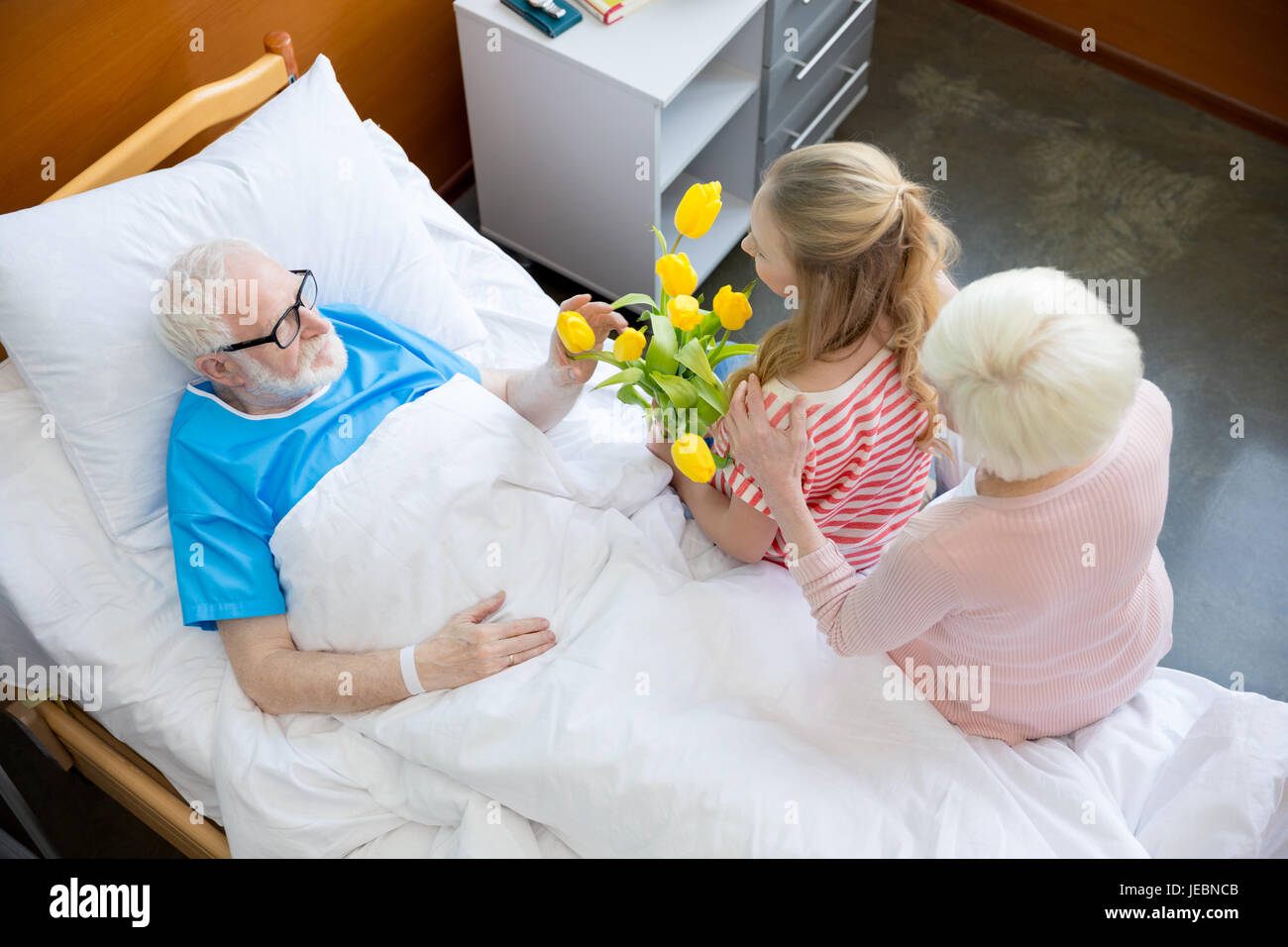 grandmother and granddaughter with tulip flowers visiting patient in ...