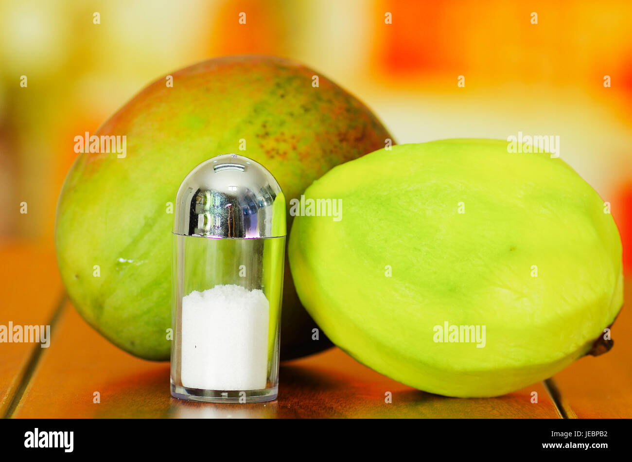 close up shot of raw and peeled mango behind salt shaker Stock Photo ...