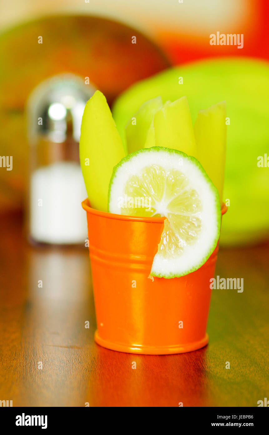 Close up shot of sliced mango served with lemon on a plastic cup Stock ...