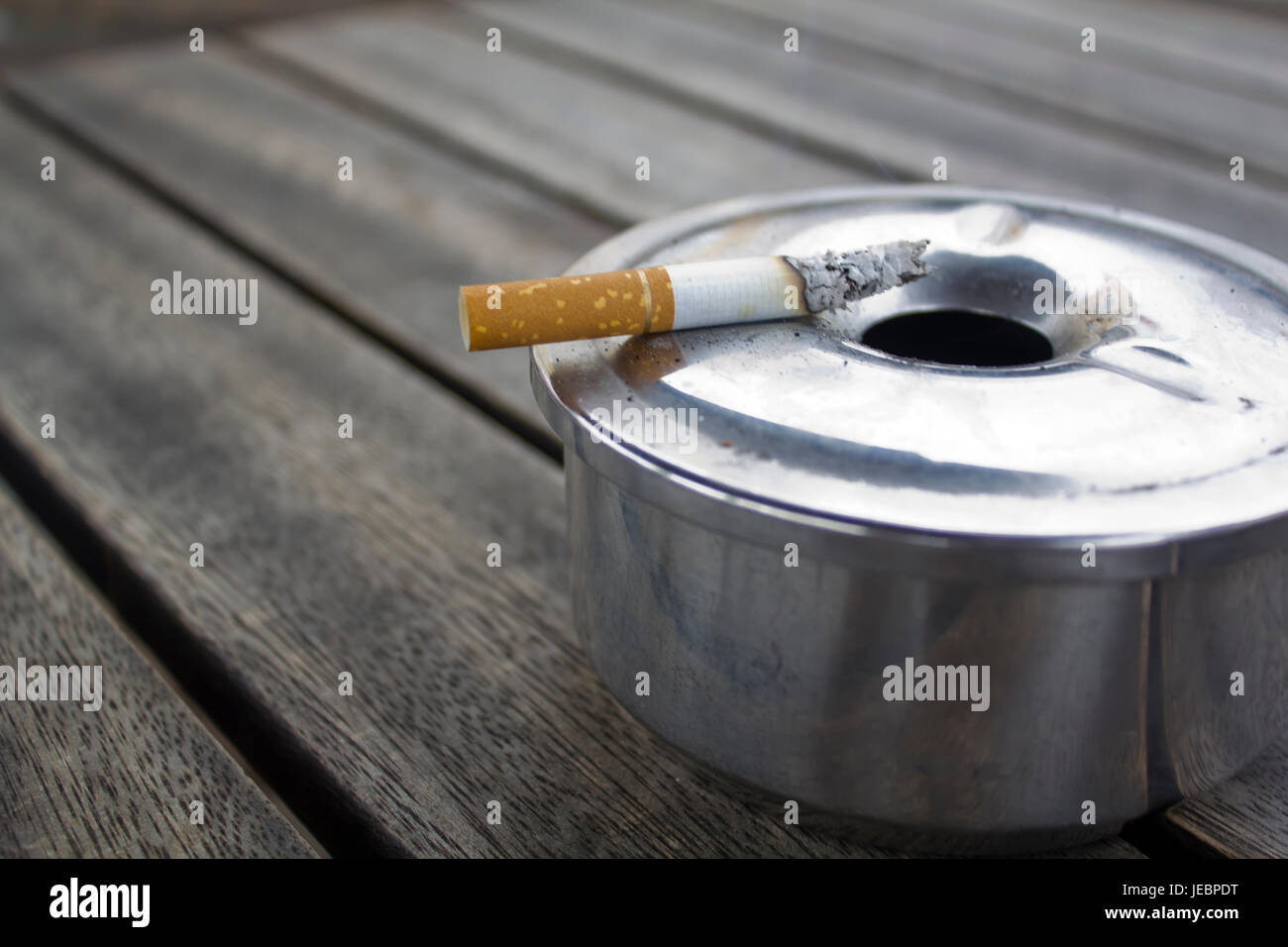 Cigarette and Ashtray on a wood table Stock Photo - Alamy