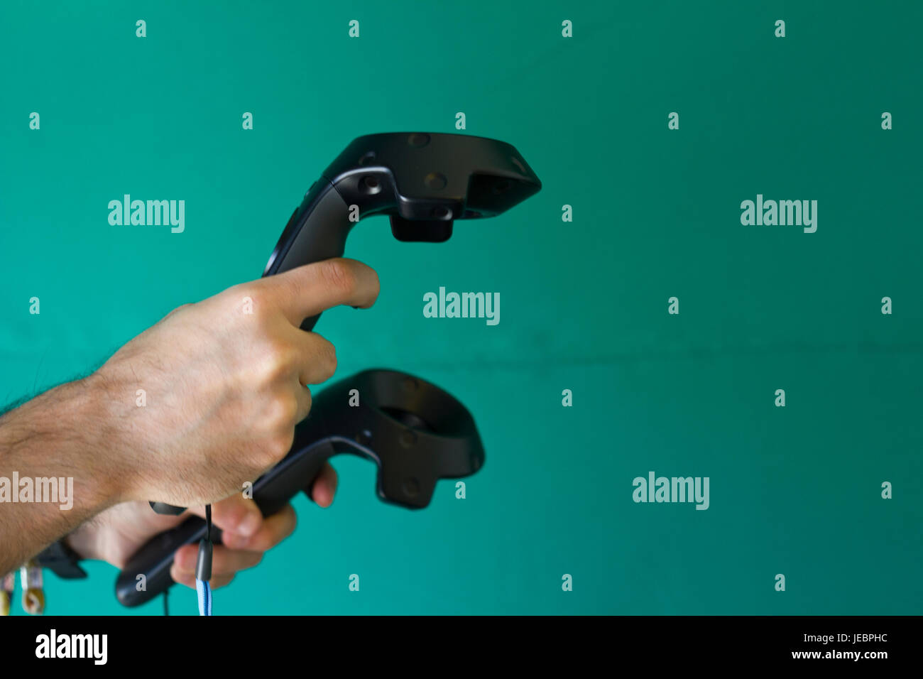 Man Hands holding VR controls on a green background Stock Photo - Alamy