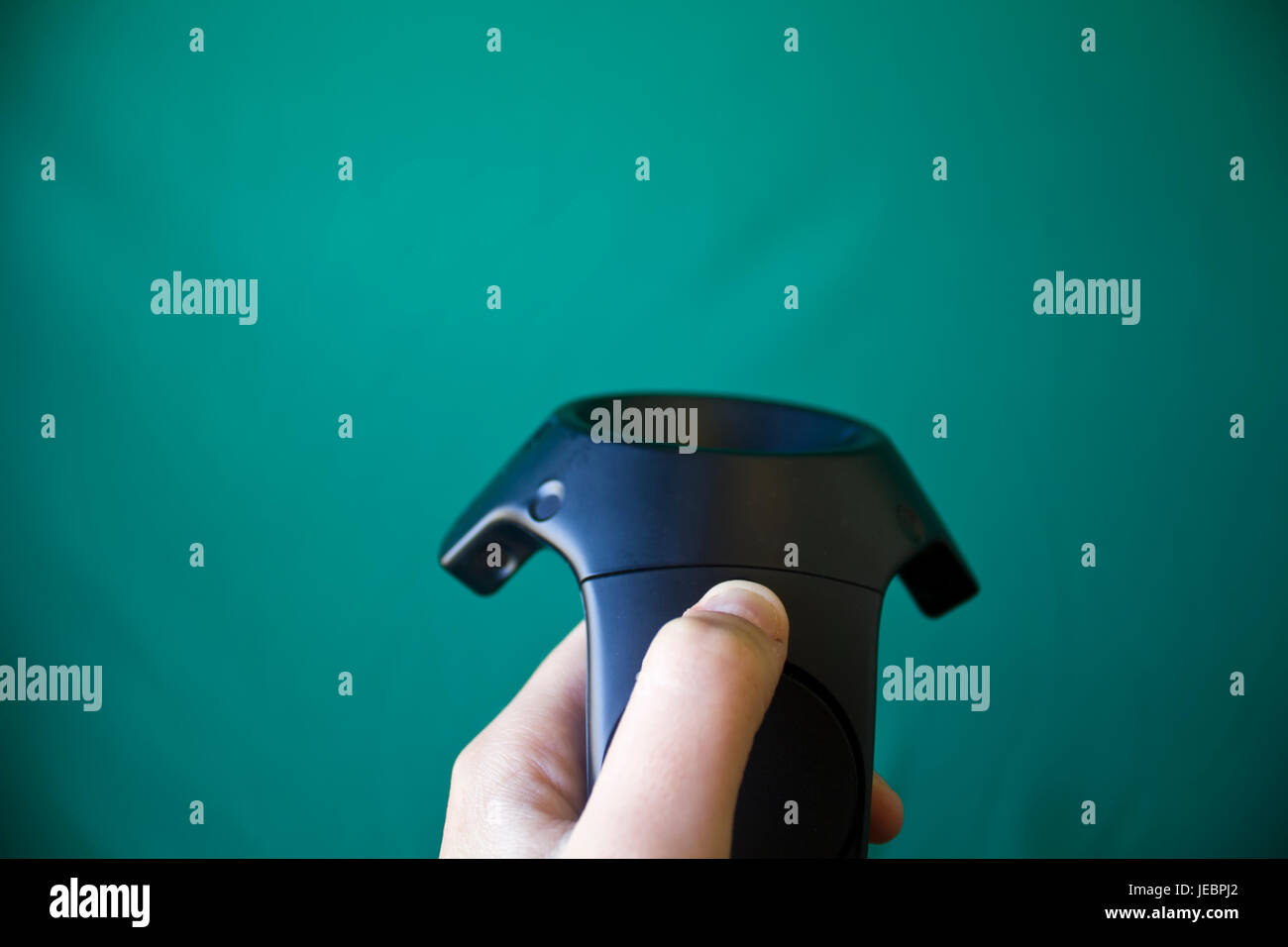 Hand holding VR control on a green background Stock Photo - Alamy