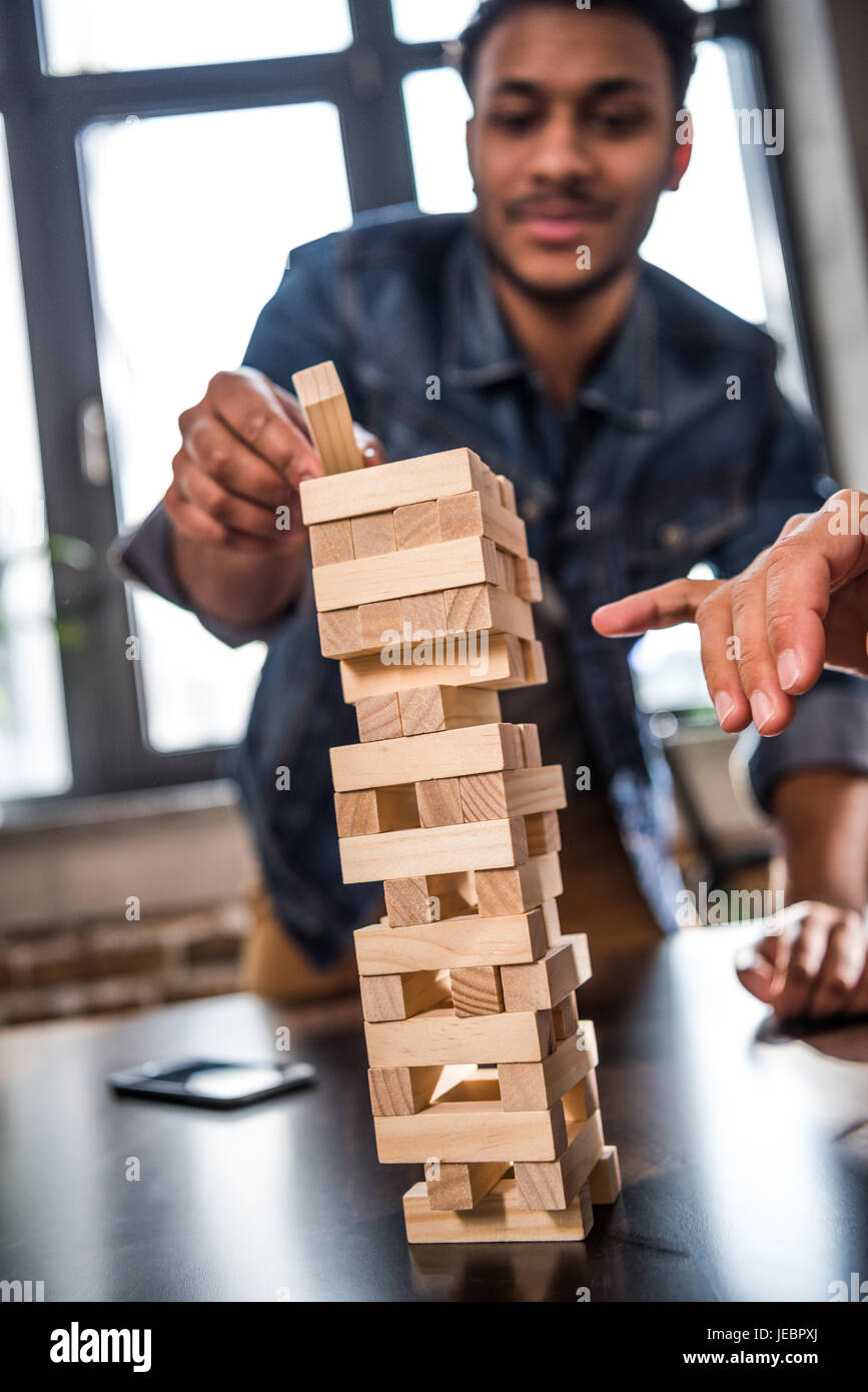 happy friends playing jenga game, focus on foreground Stock Photo - Alamy