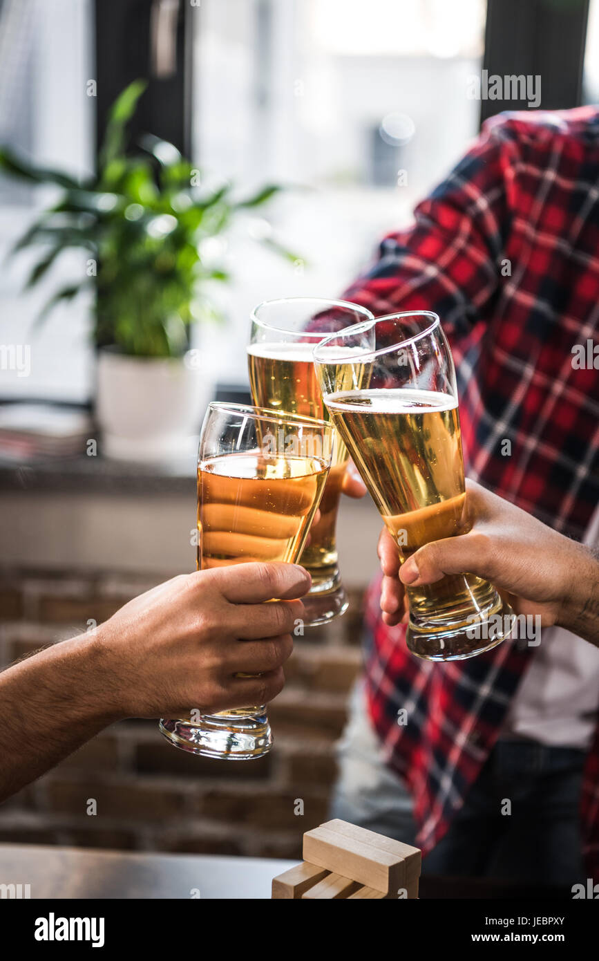 partial view of three men clinking glasses with beer Stock Photo - Alamy