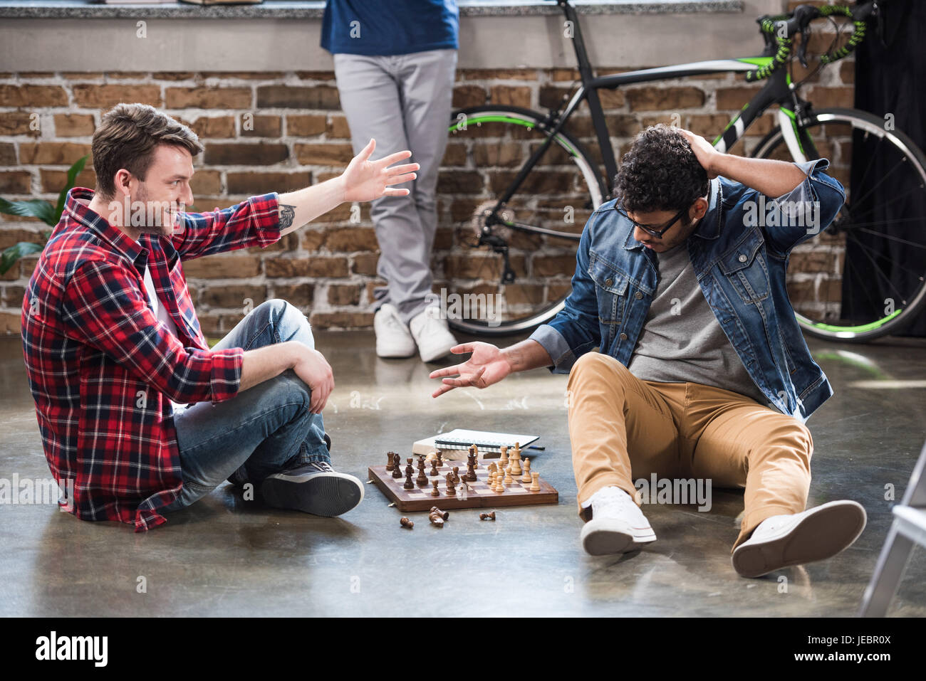 young men sitting on floor and playing chess on chess board Stock Photo ...