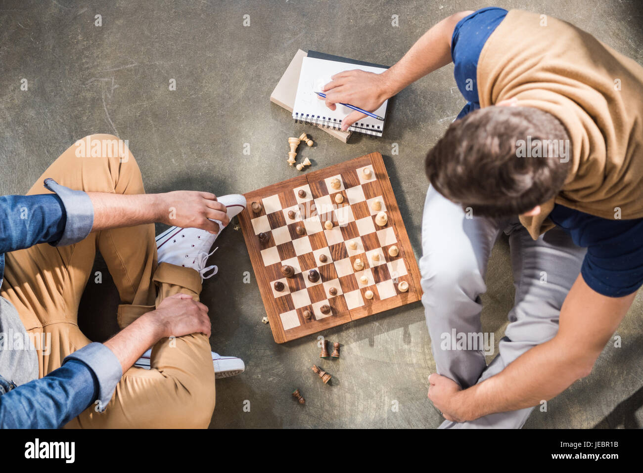 young men sitting on floor and playing chess on chess board Stock Photo ...