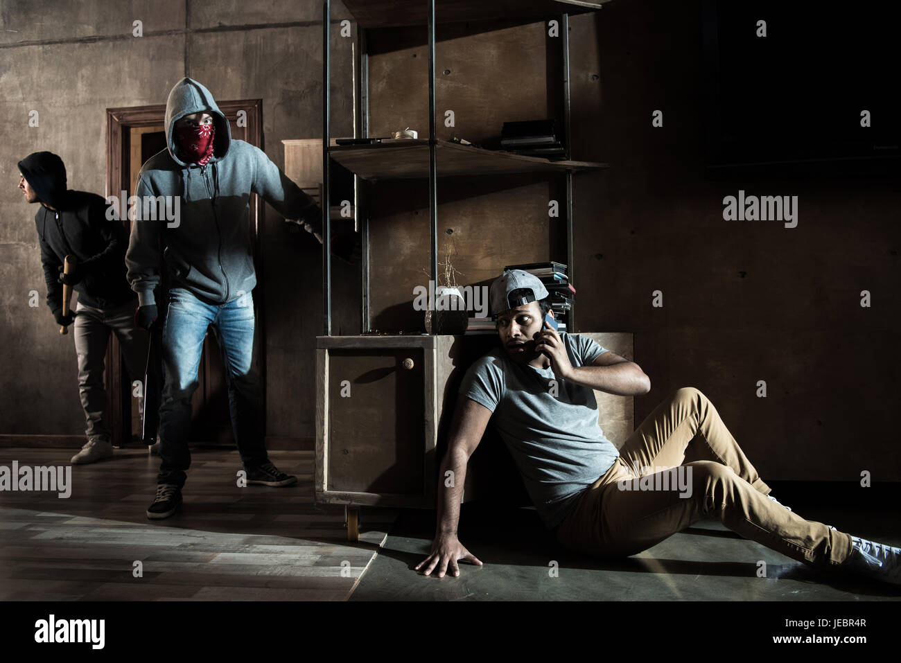 Scared man hiding from burglars breaking indoors, house robbery scene ...