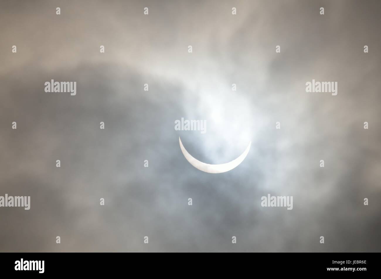 Partial Solar Eclipse seen through clouds Stock Photo - Alamy