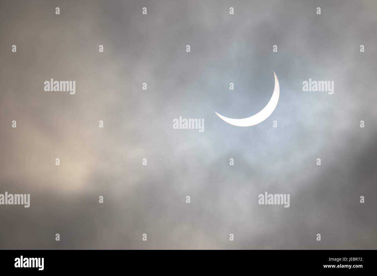 Partial Solar Eclipse seen through clouds Stock Photo - Alamy