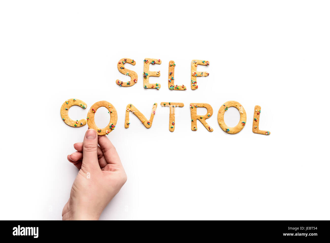 Top view of self control lettering made from sweets and hand holding ...