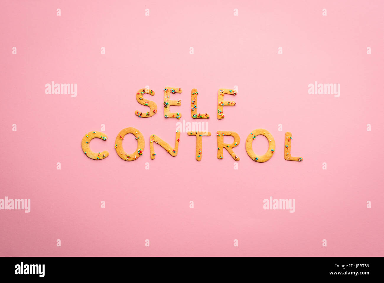 Top view of self control lettering made from sweets isolated on pink ...