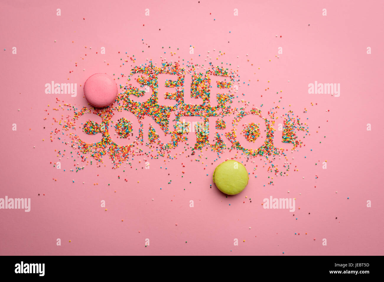 Top view of self control lettering made from candies isolated on pink ...