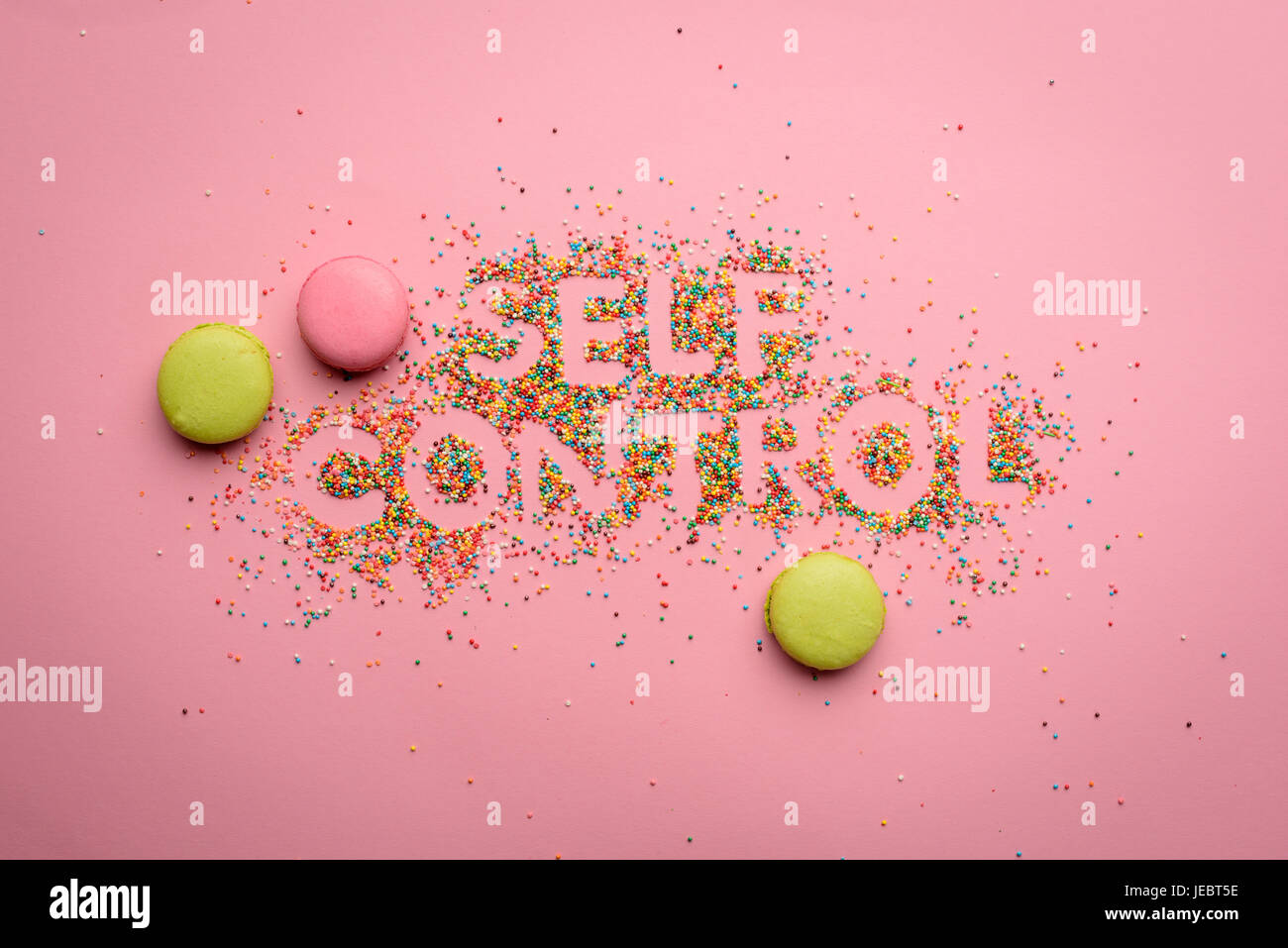 Top view of self control lettering made from candies isolated on pink ...