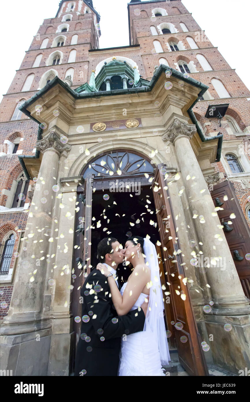 Bride and groom before church, kiss, confetti Stock Photo - Alamy