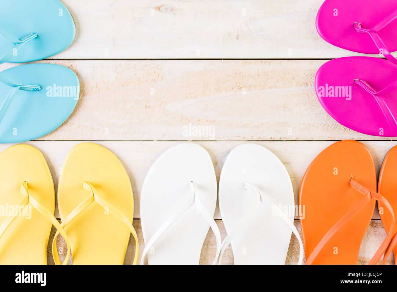 Bright women's flip flops on a wood board Stock Photo - Alamy