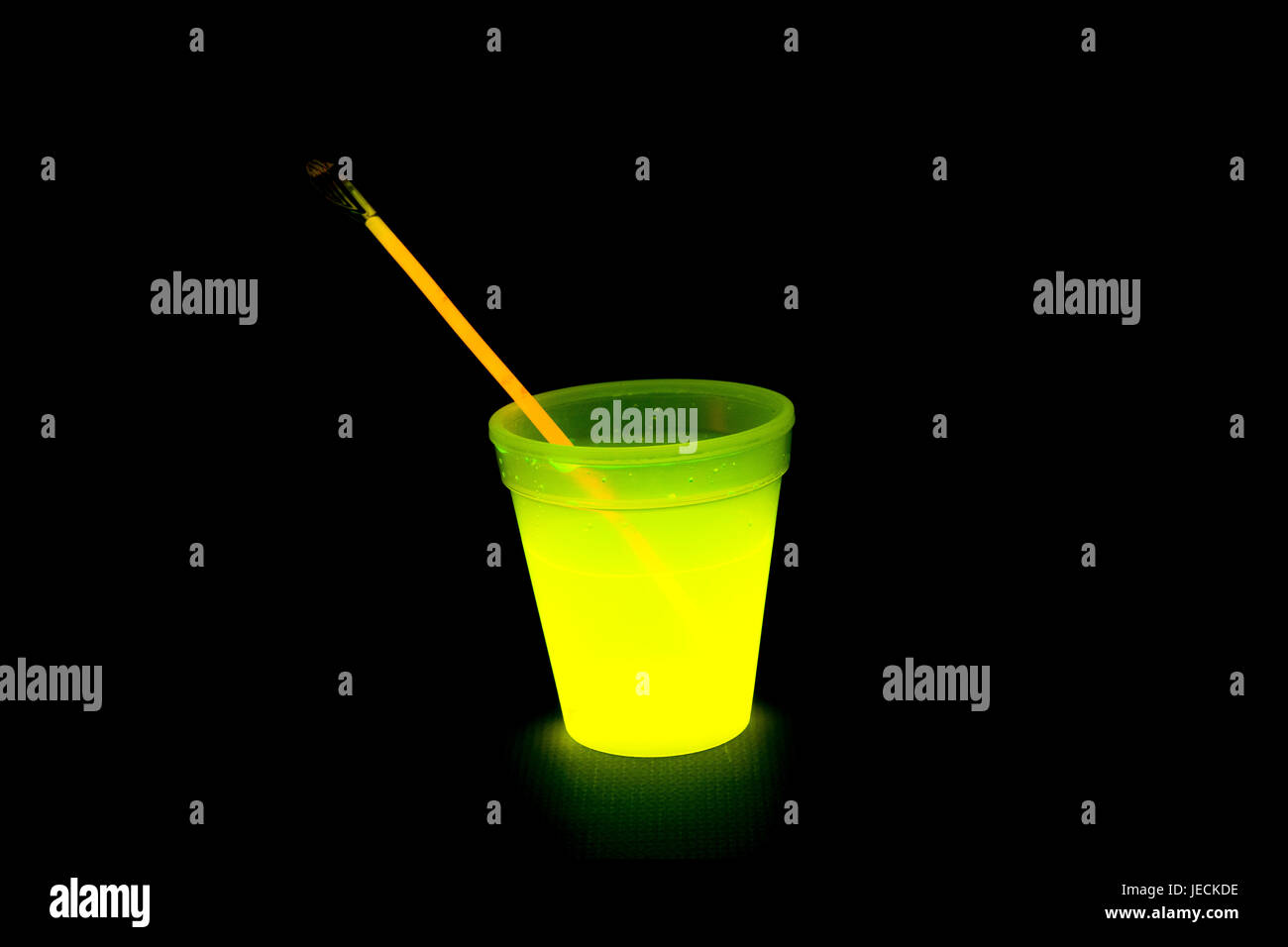 Yellow fluorescent glass with glow sticks neon light on back background ...
