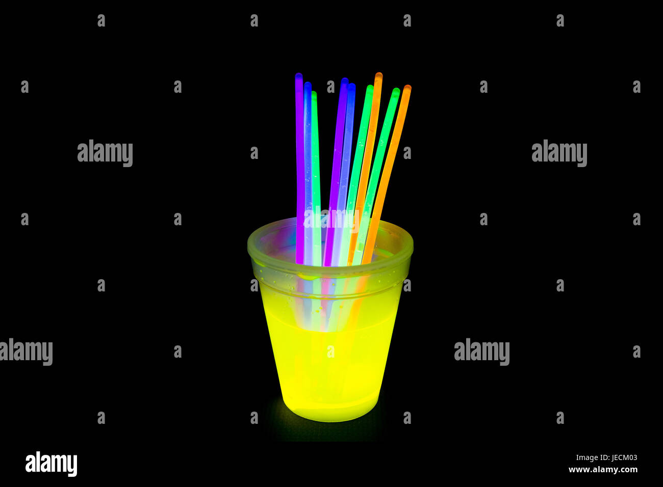 Yellow fluorescent glass with glow sticks neon light on back background ...