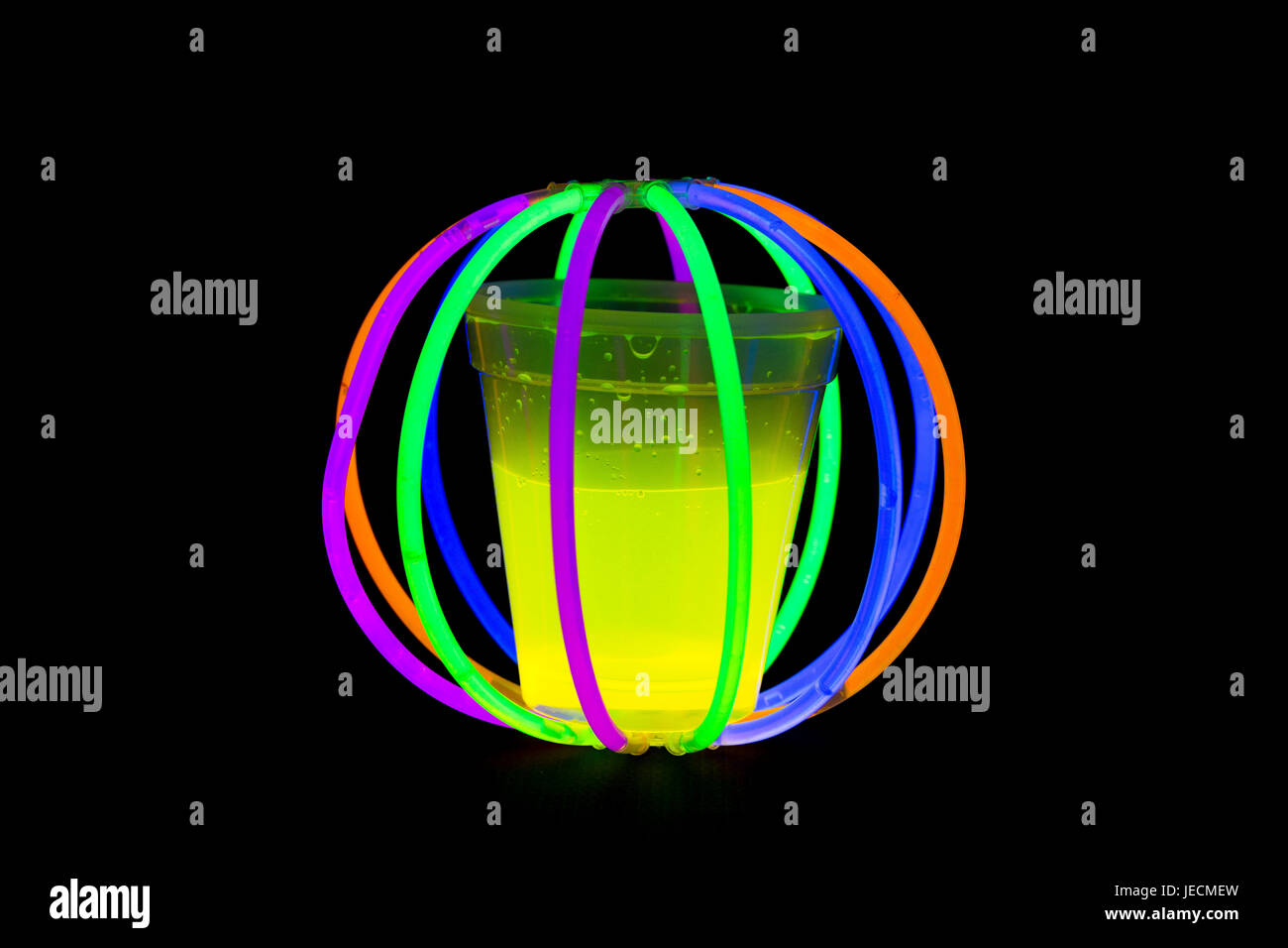 Yellow fluorescent glass in ball with glow sticks neon light on back ...