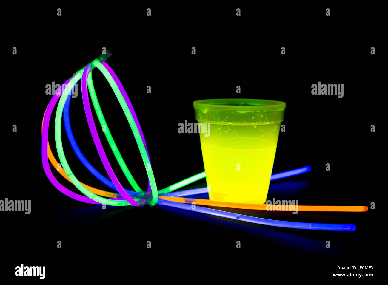 Yellow fluorescent glass and ball made with glow sticks neon light on ...