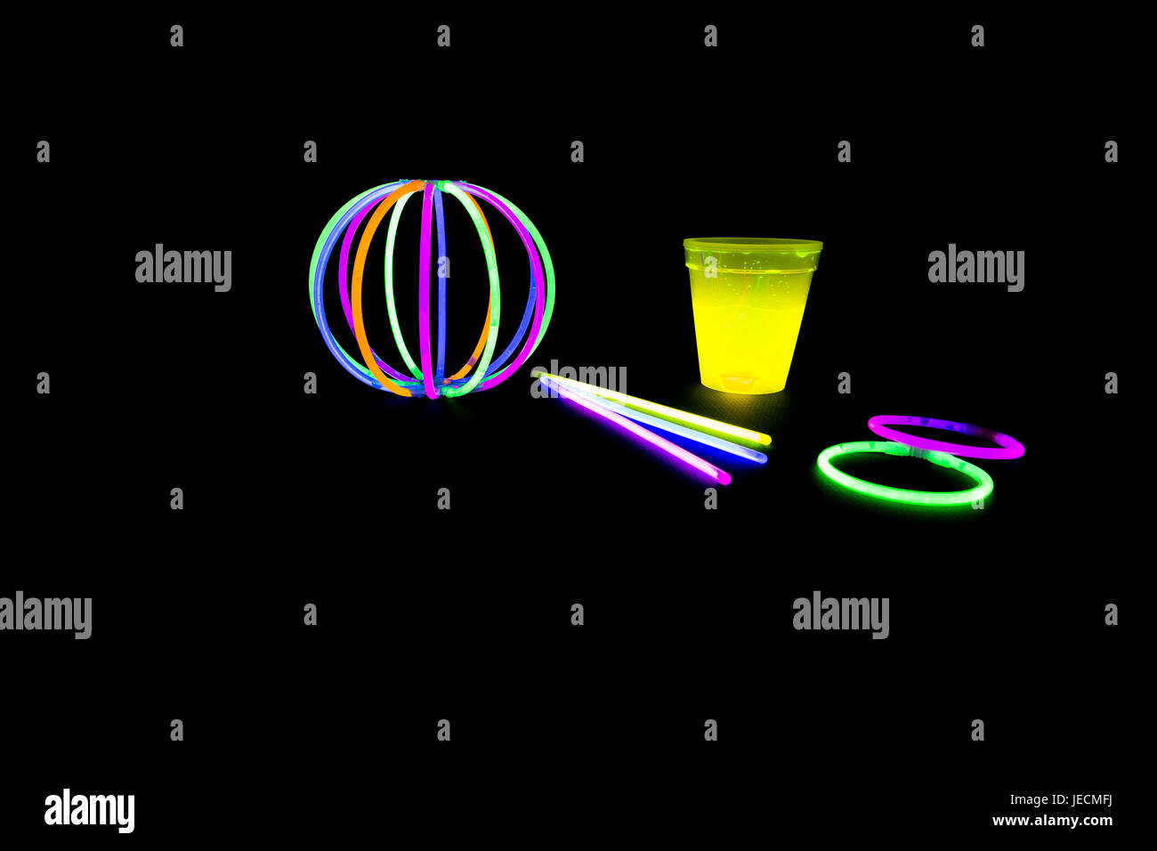 Yellow fluorescent glass and ball with glow sticks neon light on back ...